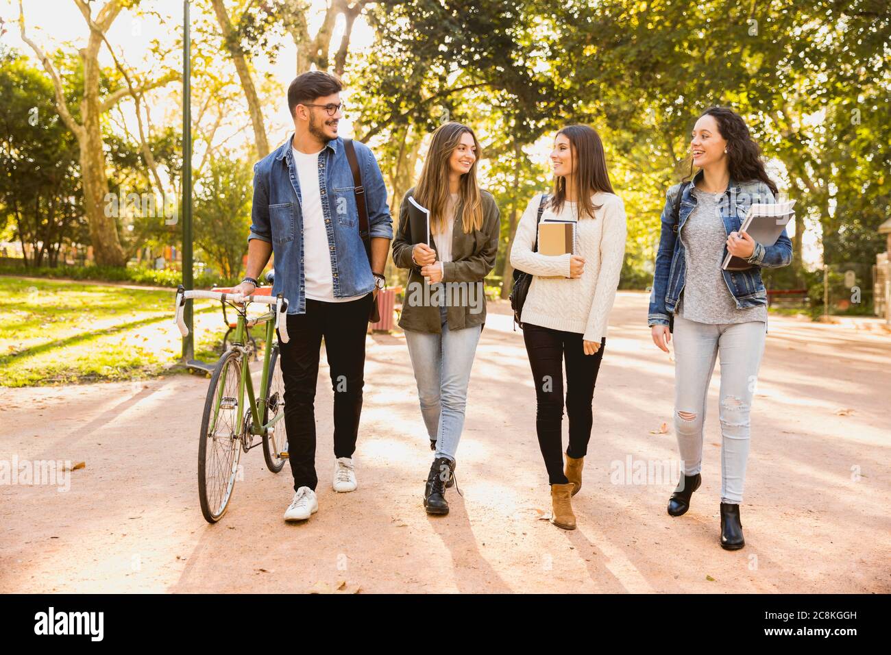Group of students walking together in the park Stock Photo - Alamy