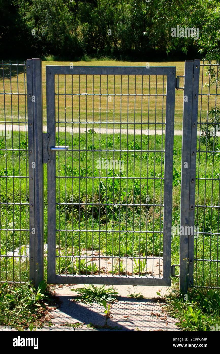 Metal door and grille in a fence Stock Photo - Alamy