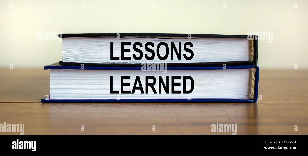 Books with text 'lessons learned' on beautiful wooden table. White ...