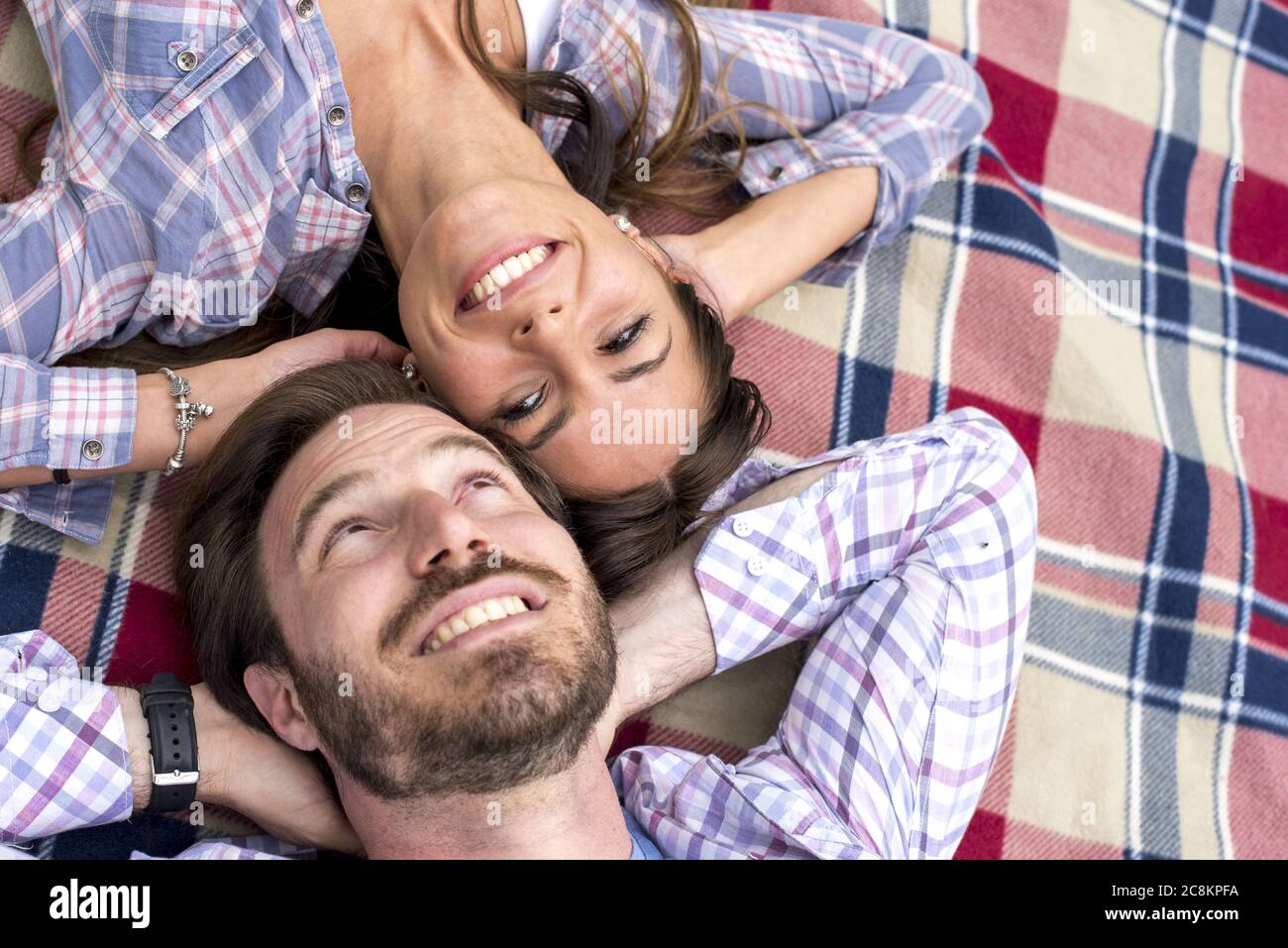 Closeup shot of a happy couple lying down on the striped surface Stock ...