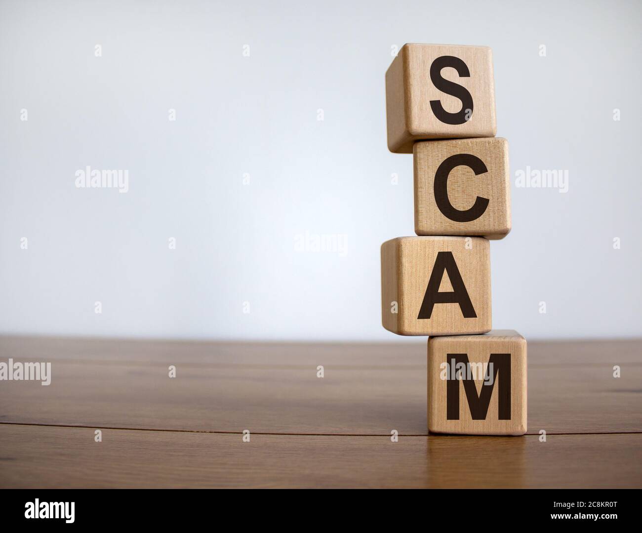 Concept word 'scam' on cubes on a beautiful wooden table. White ...