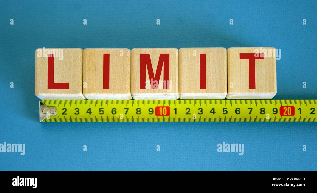 'Limit' word on cubes arranged behind the ruler on beautiful blue ...