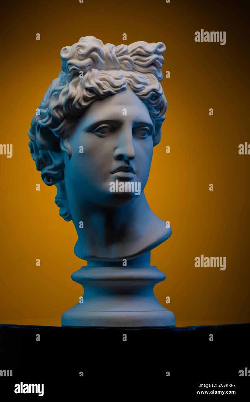 Plaster statue of a bust of Apollo Belvedere in blue local light on a ...