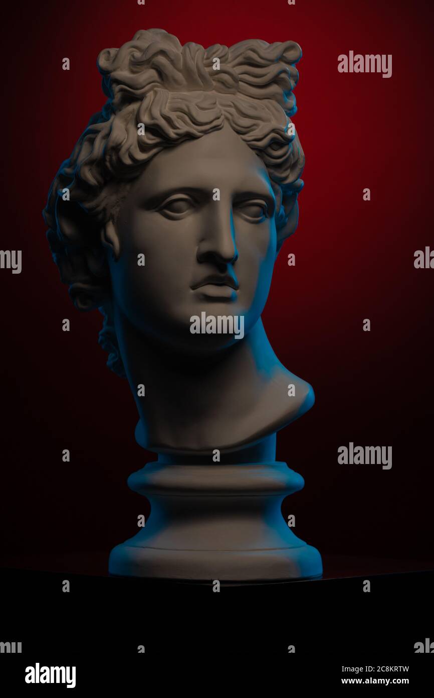 Plaster statue of a bust of Apollo Belvedere in blue local light on a ...