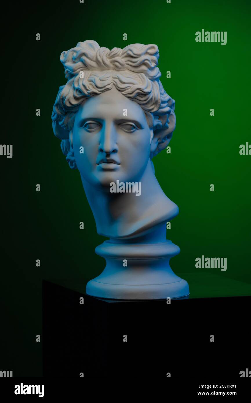 Plaster statue of a bust of Apollo Belvedere in blue local light on a ...