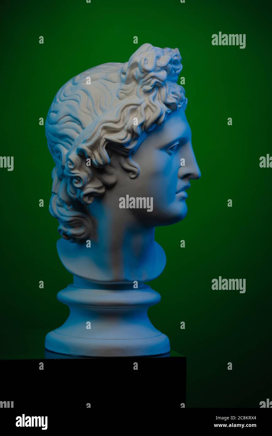Plaster statue of a bust of Apollo Belvedere in blue local light on a ...