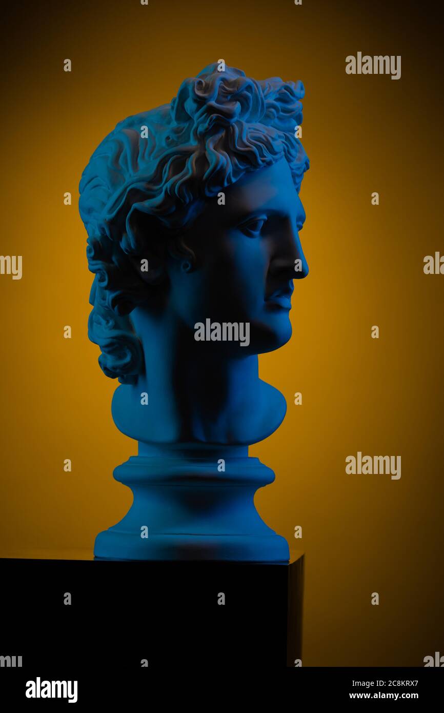 Plaster statue of a bust of Apollo Belvedere in blue local light on a ...