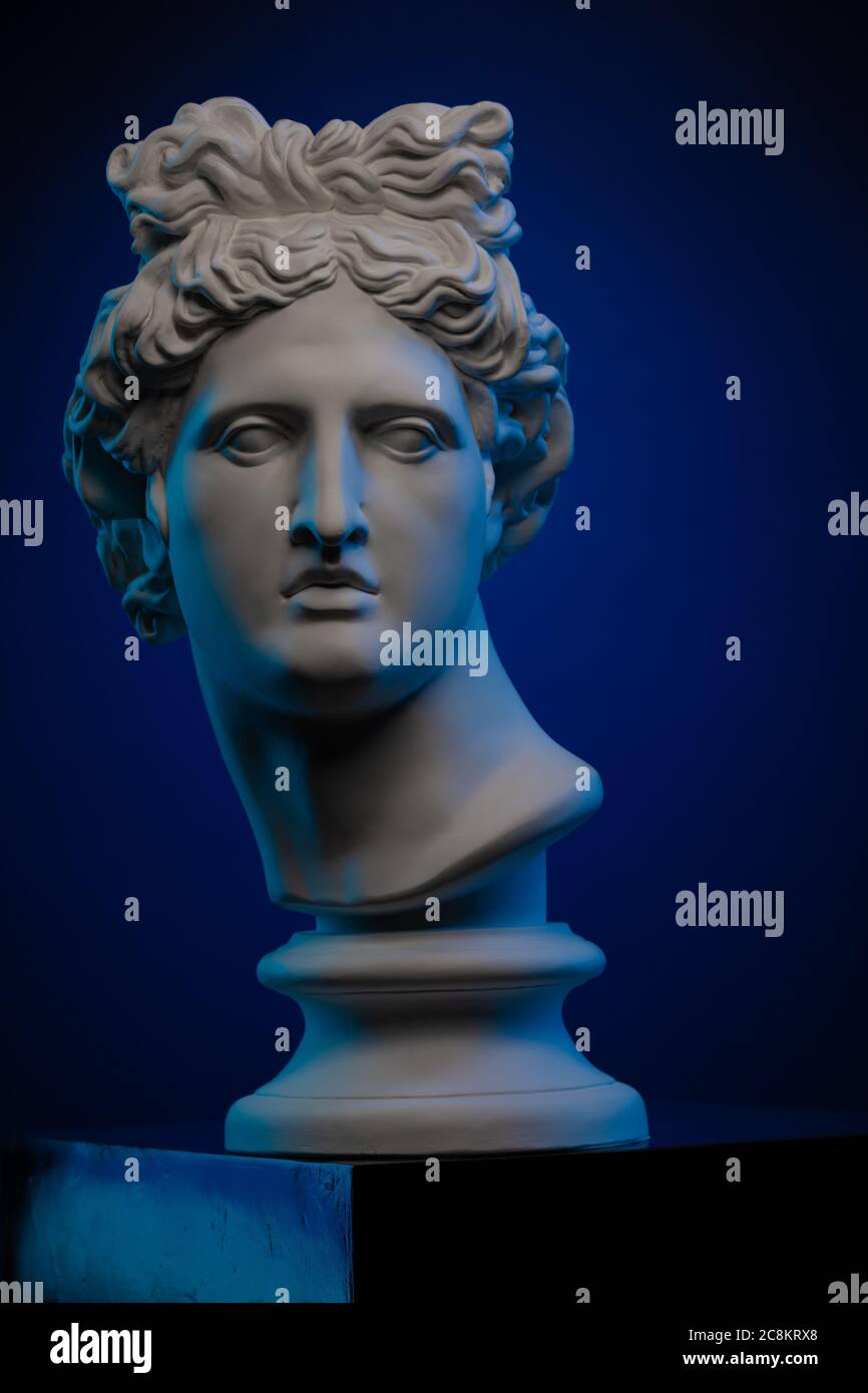 Plaster statue of a bust of Apollo Belvedere in blue local light on a ...