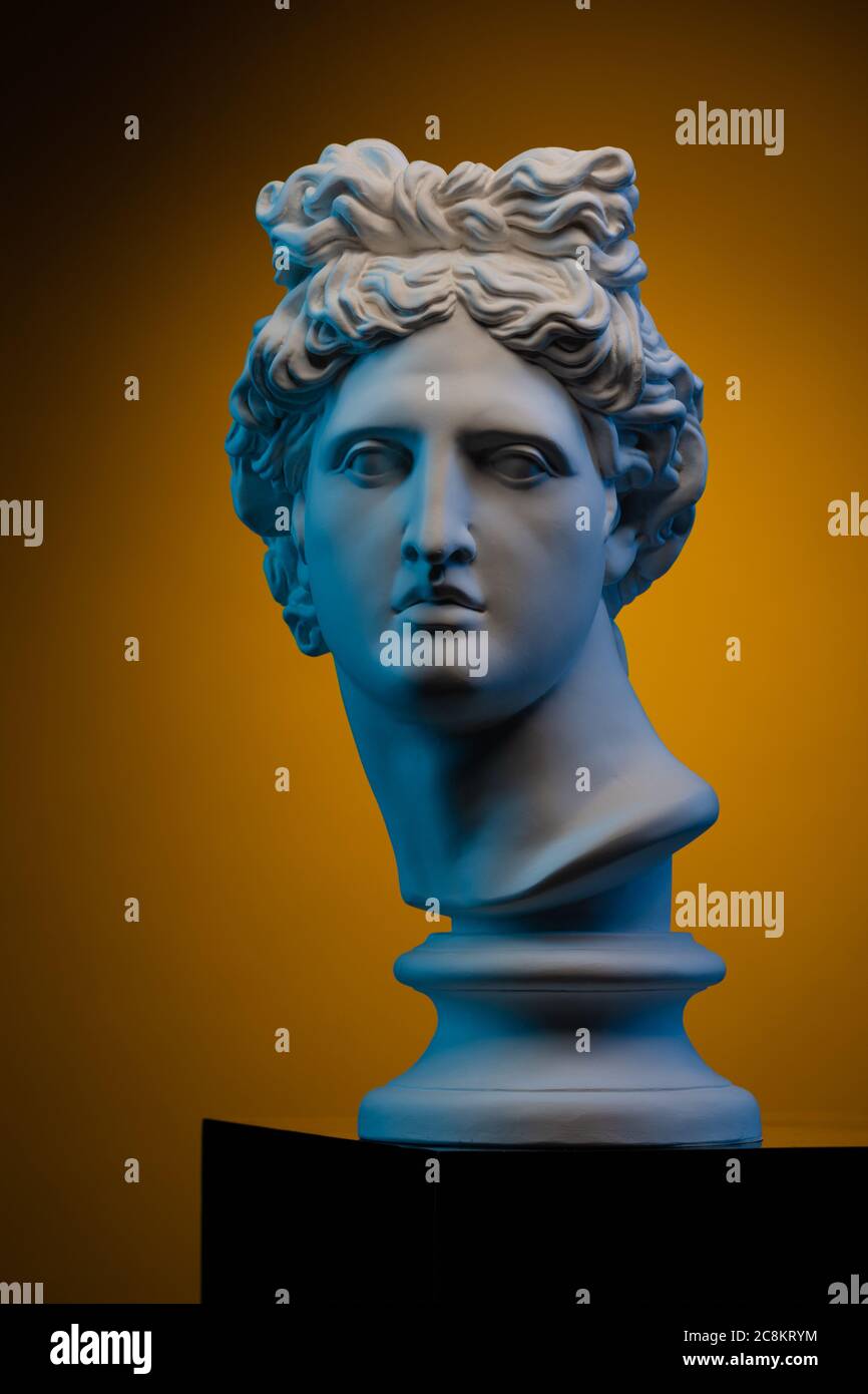 Plaster statue of a bust of Apollo Belvedere in blue local light on a ...