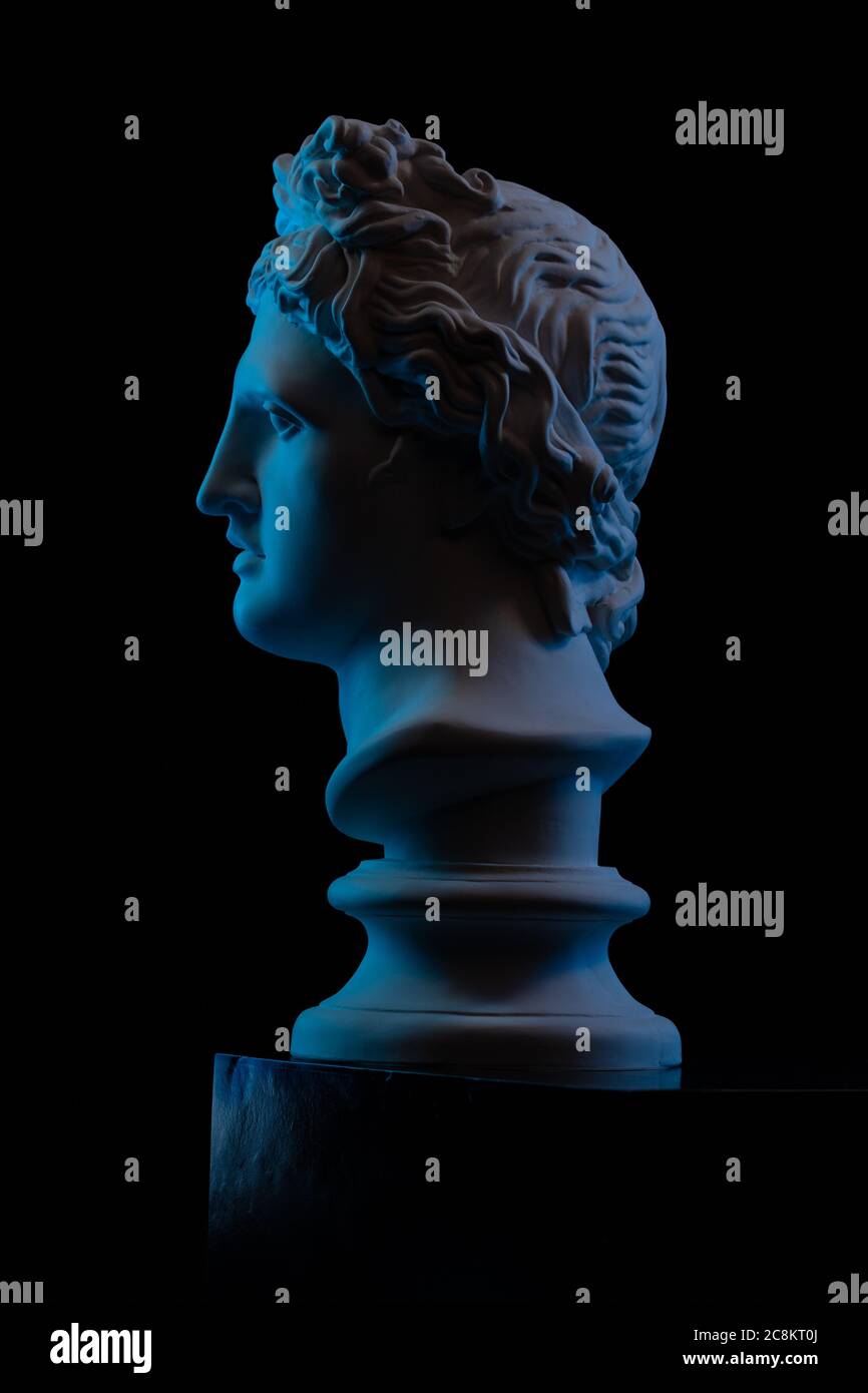 Plaster statue of a bust of Apollo Belvedere in blue local light on a ...