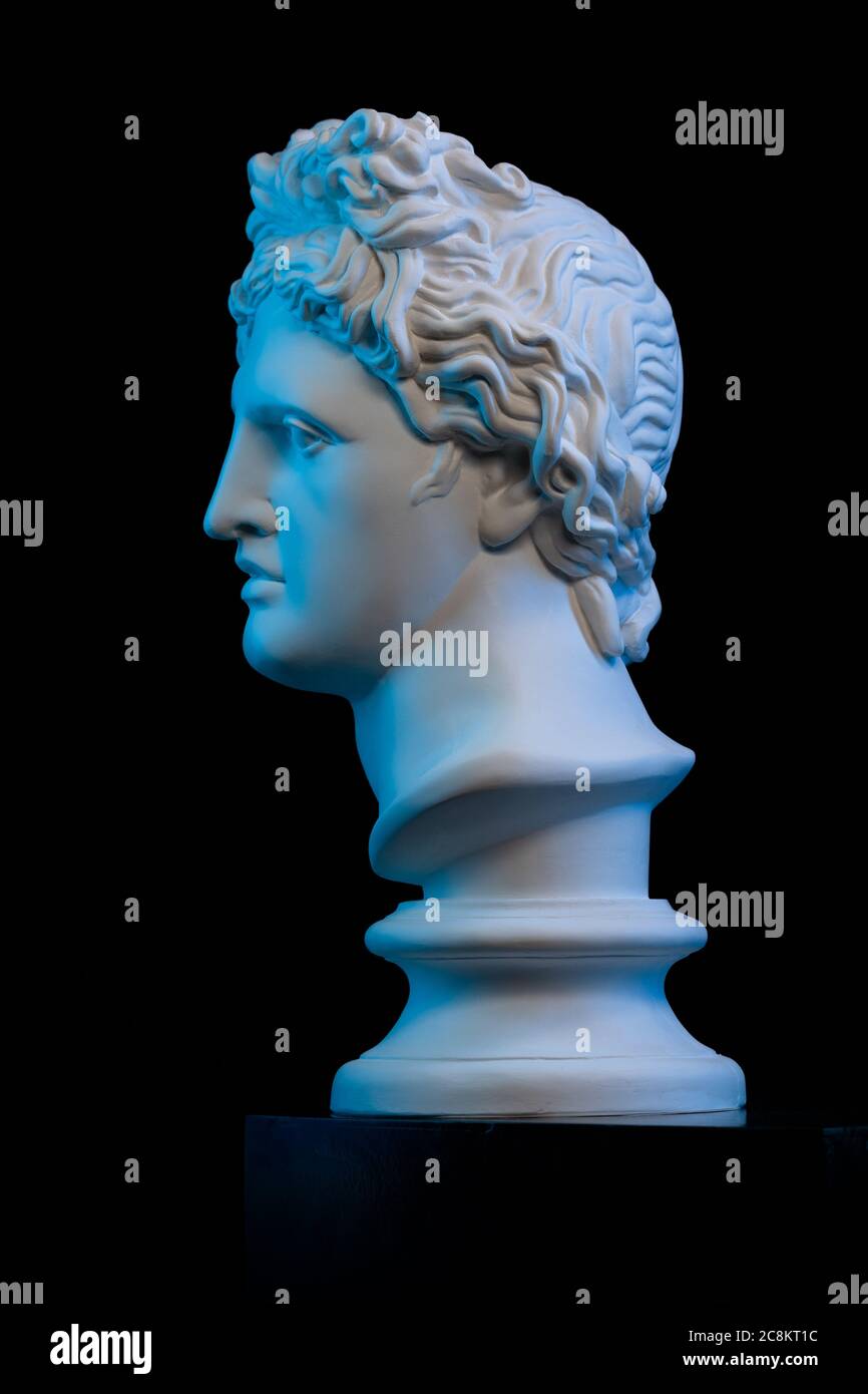Plaster statue of a bust of Apollo Belvedere in blue local light on a ...