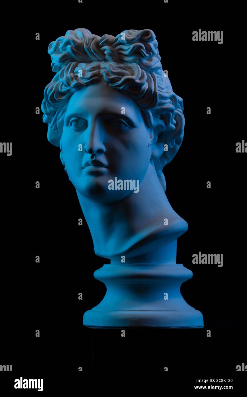 Statue of a bust of Apollo's head in blue local light on a blue black ...