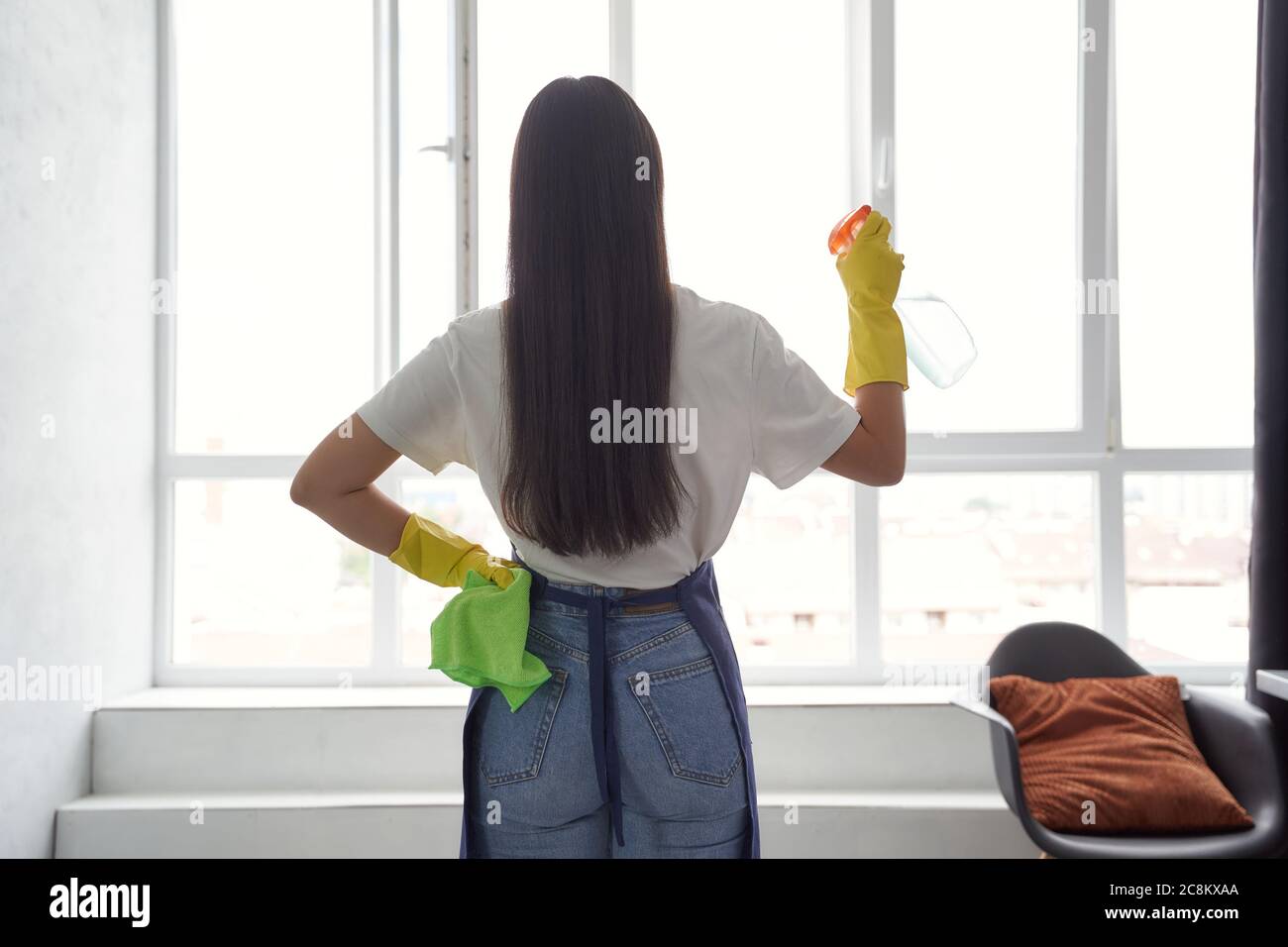 Washing windows professionally. Back view of a young woman, cleaning ...