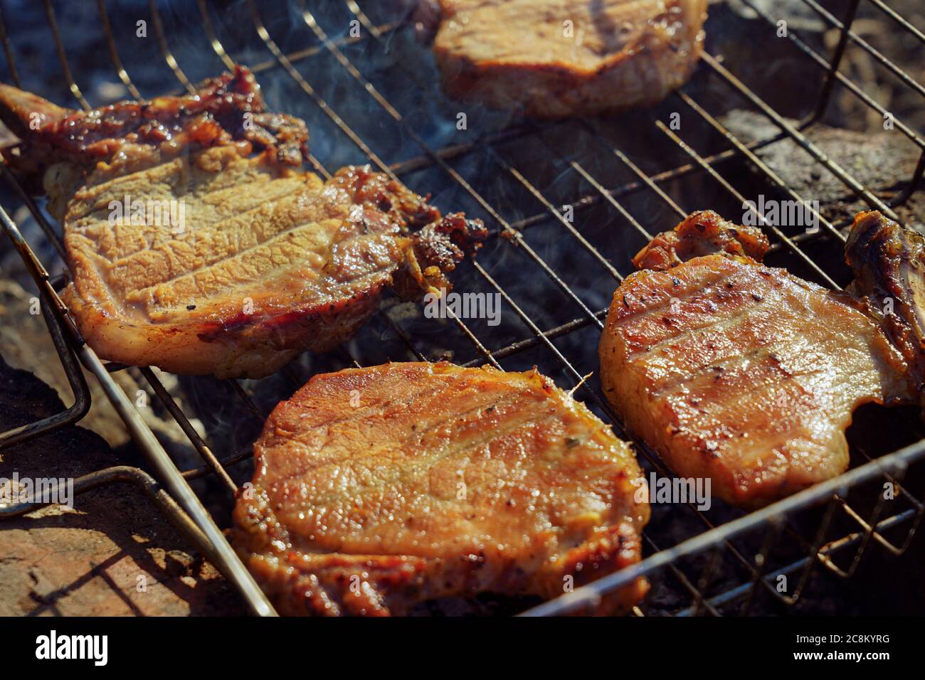 Grilled pork steaks lay over coals on a grill Stock Photo - Alamy