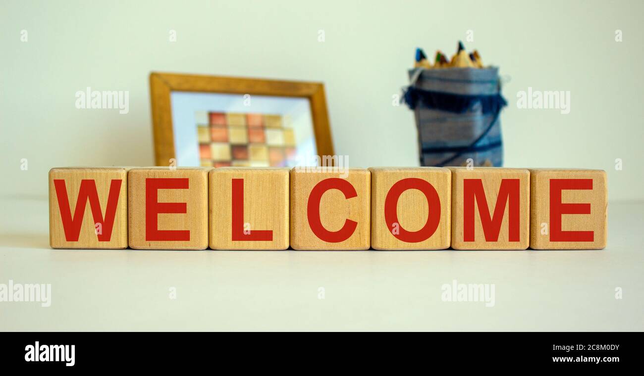 Wooden cubes with the inscription 'welcome'. Frame with a picture and a ...