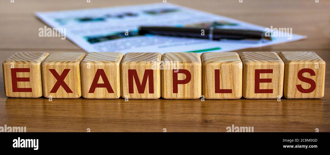 Concept word 'examples' on cubes on a beautiful wooden table, pen and ...