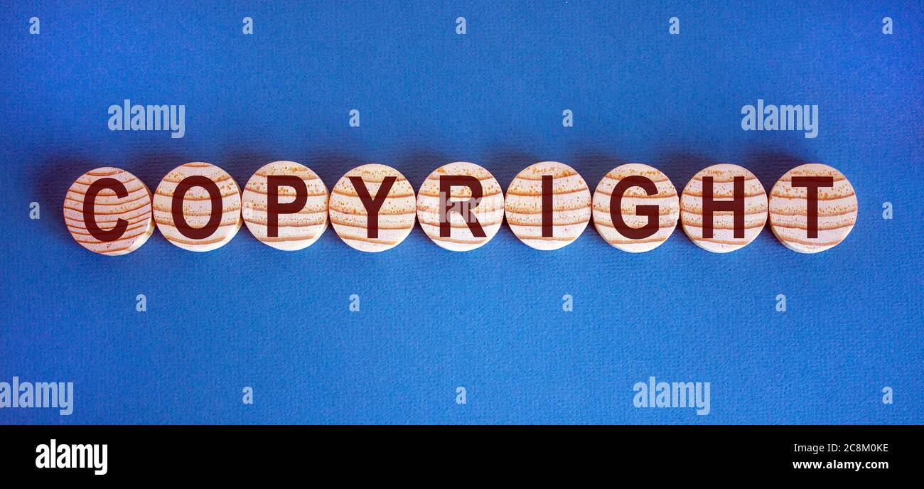 Wood circles with word 'copyright' on blue paper, copy space. Business ...