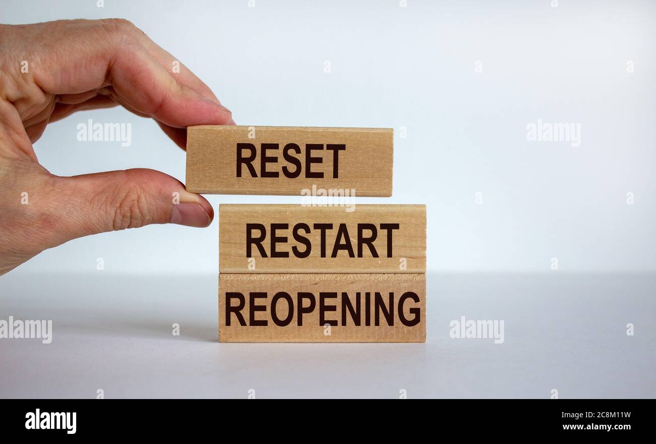 Male hand placing a blocks with word 'reset' on top of a blocks tower ...