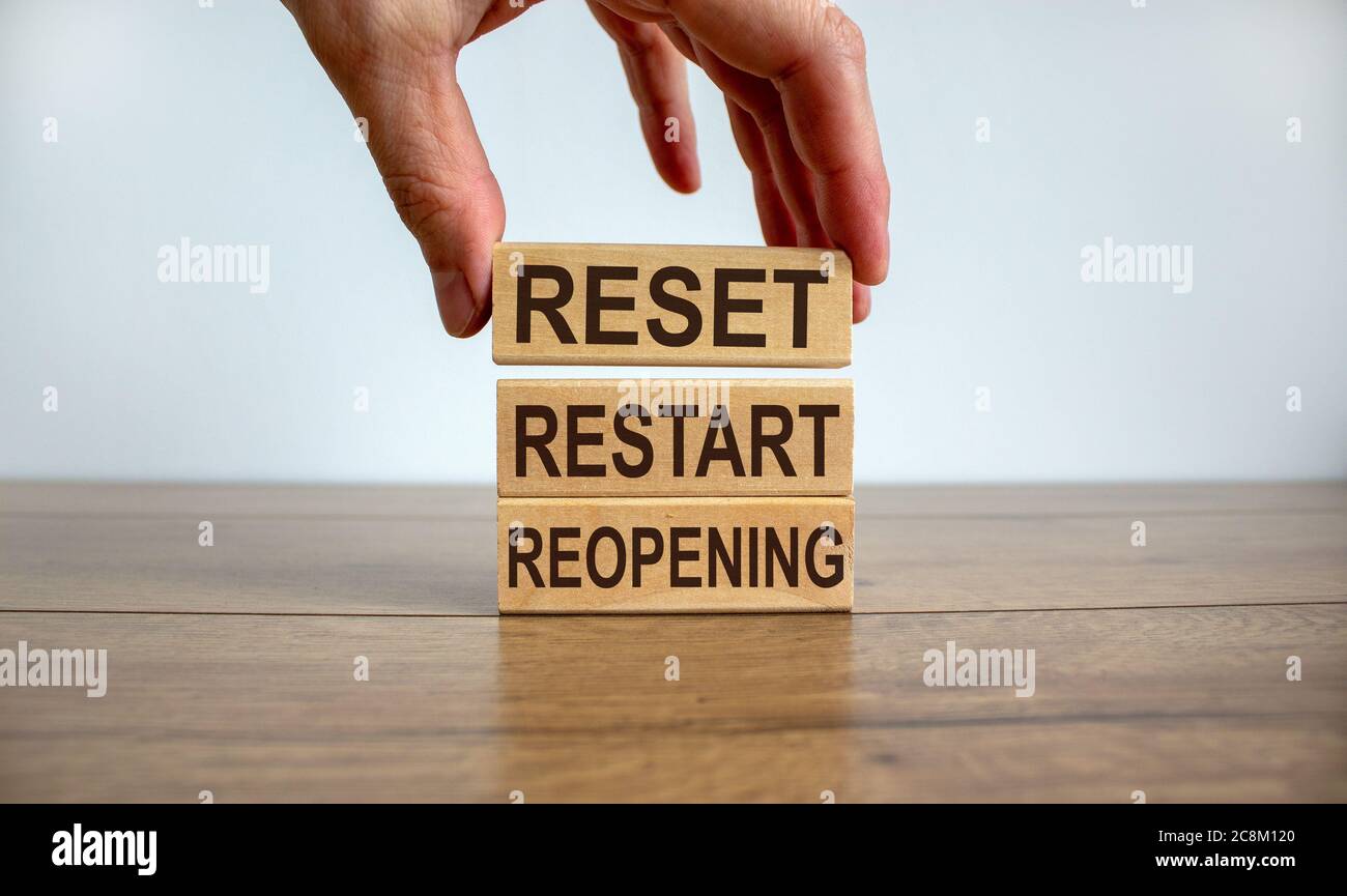 Male hand placing a block with word 'reset' on top of a blocks tower on ...