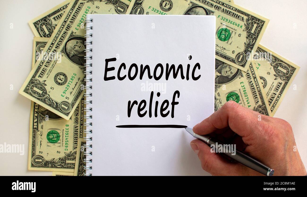 Male hand writing 'economic relief' on white note, on white background ...