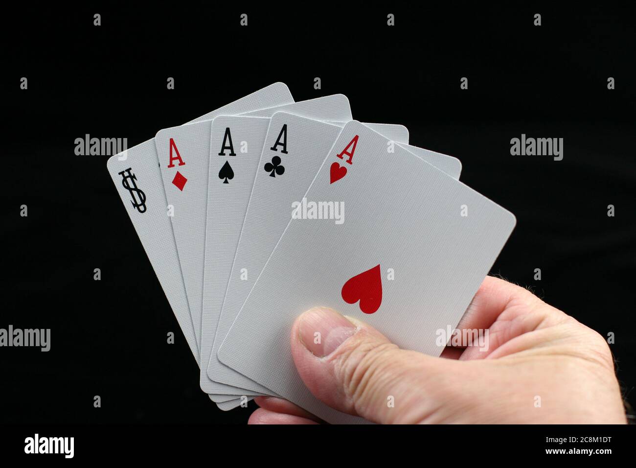 Hand holding poker playing cards over black background Stock Photo - Alamy