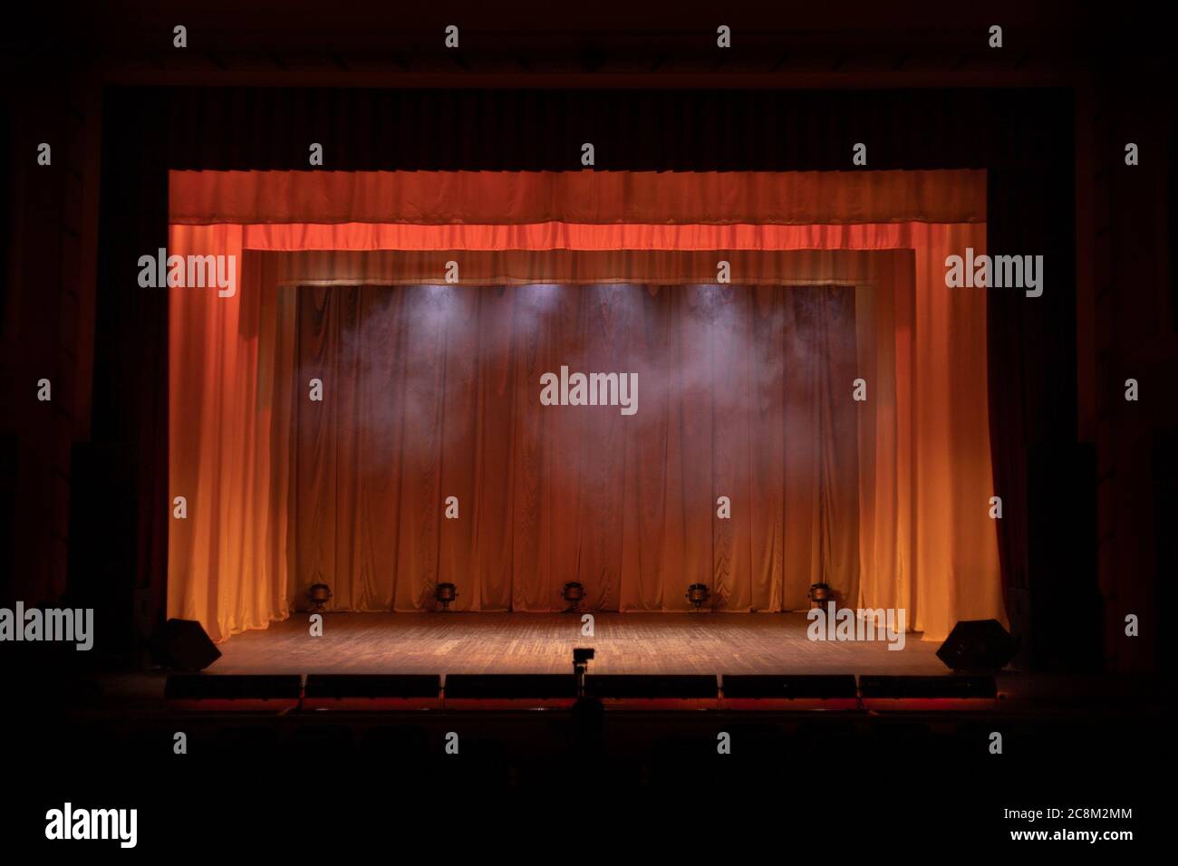 An empty stage of the theater, lit by spotlights and smoke before the ...