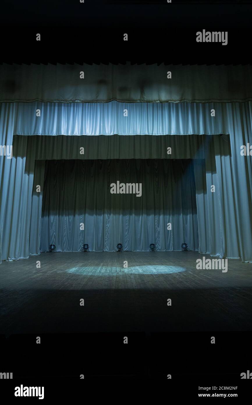An empty stage of the theater, lit by spotlights and smoke before the ...