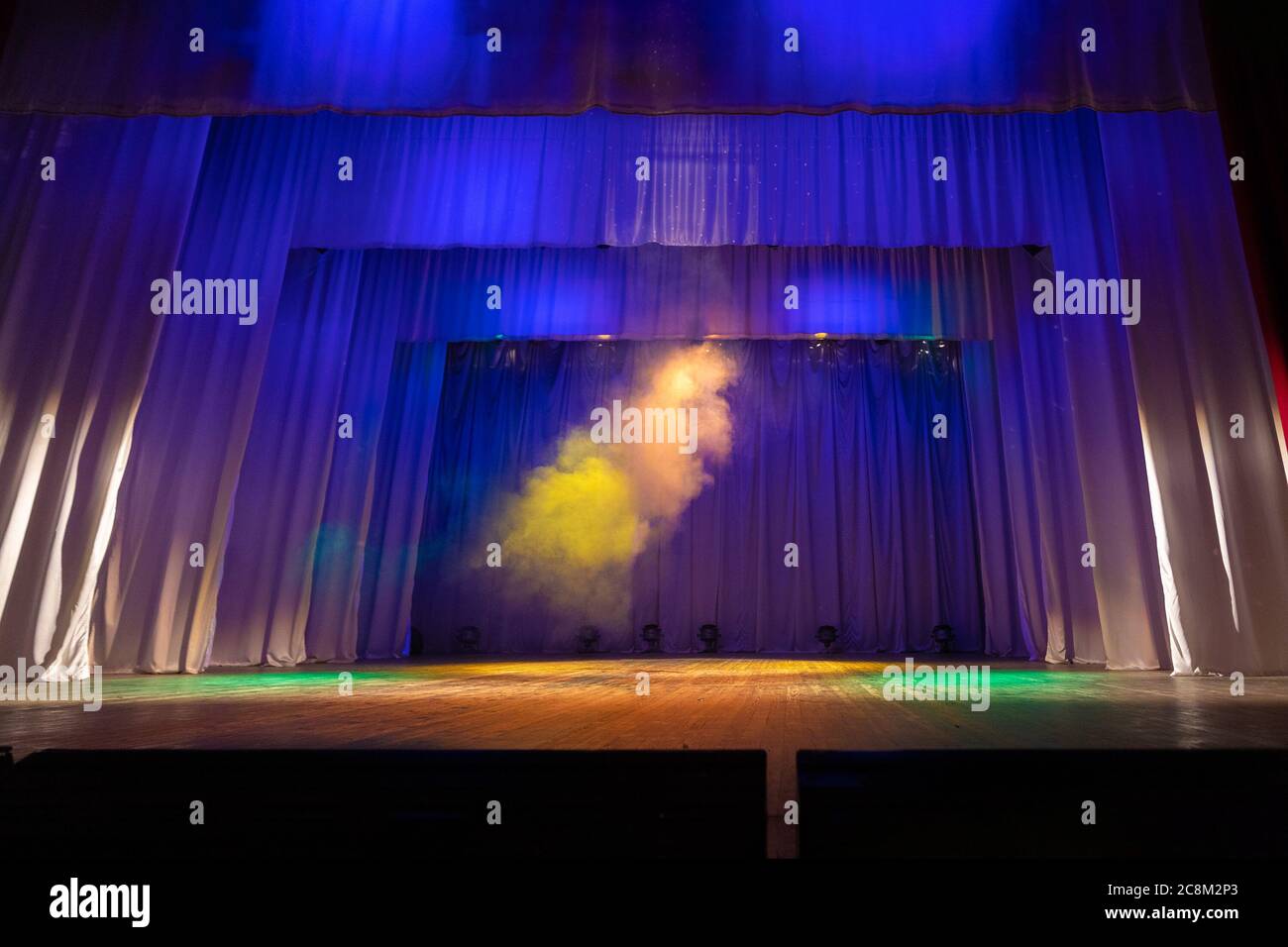 Theater stage, colored puffs of smoke in stage light Stock Photo - Alamy