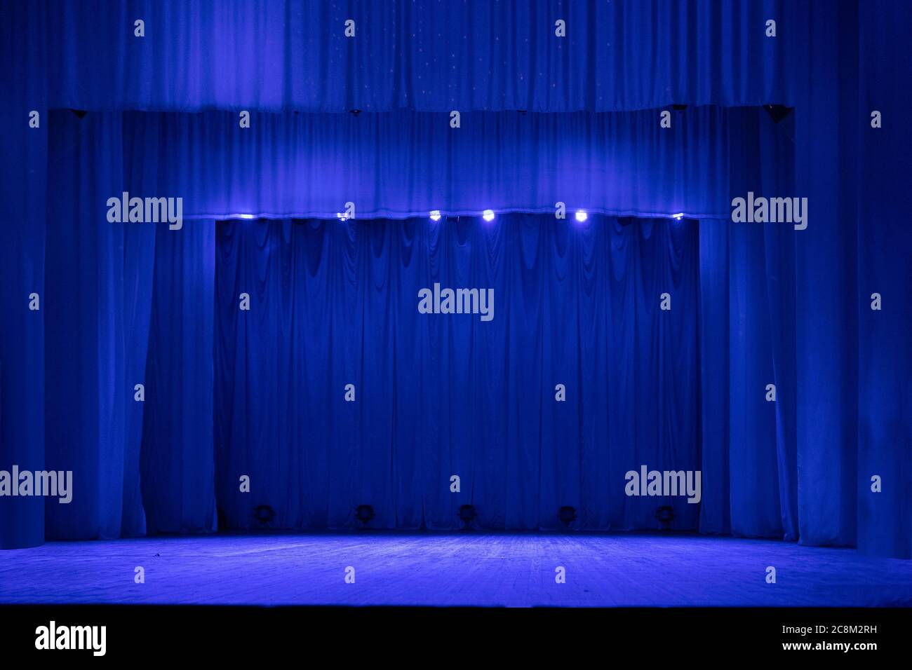 An empty stage of the theater, lit by spotlights and smoke before the ...