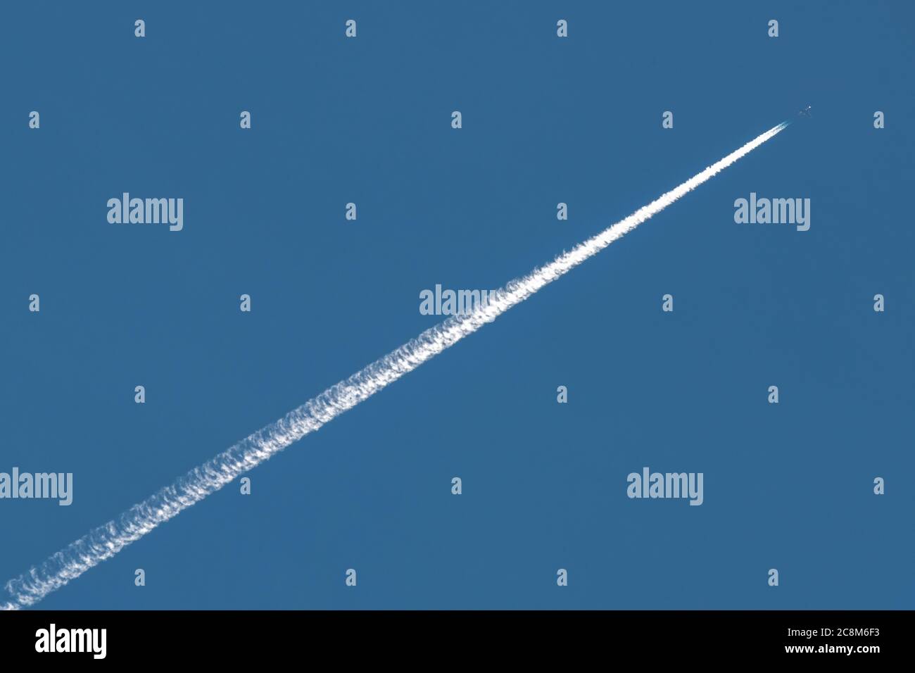 Airplane in the Sky and its Exhaust Fumes Stock Photo - Alamy