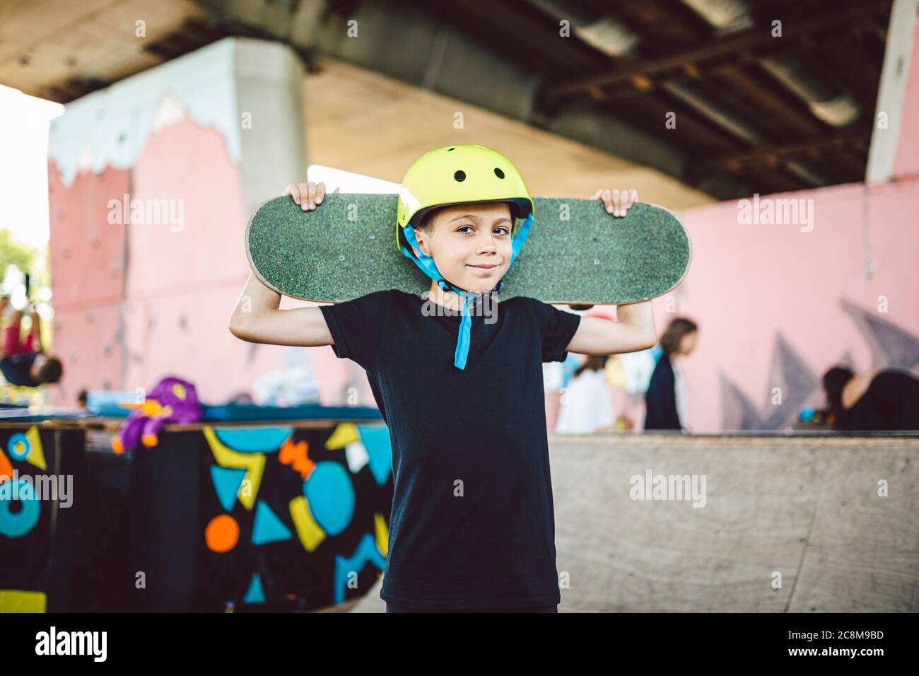Portrait boy holding skateboard over shoulder. Beautiful kid model ...