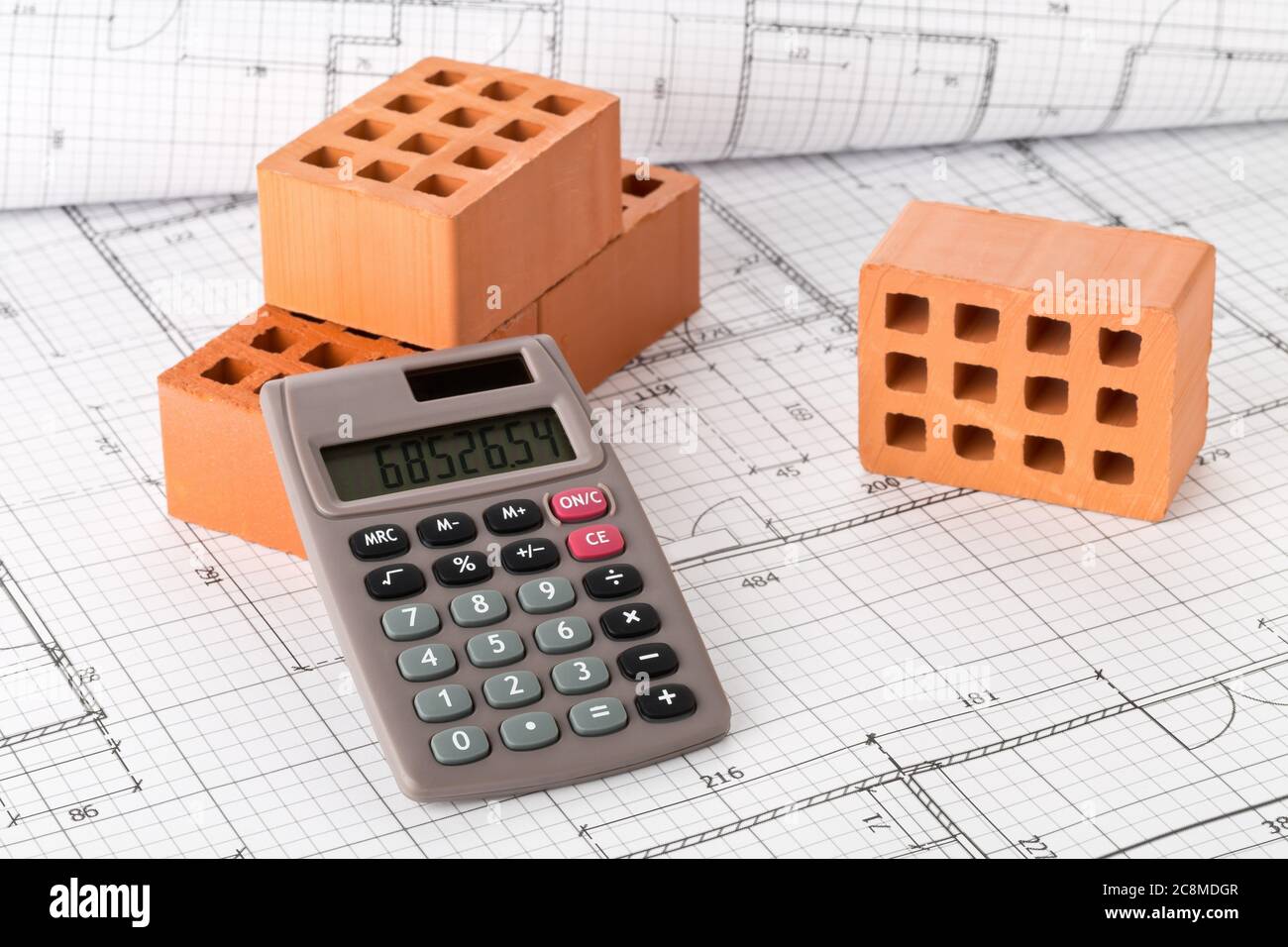 Calculator with bricks on architectural house building blueprint plan ...