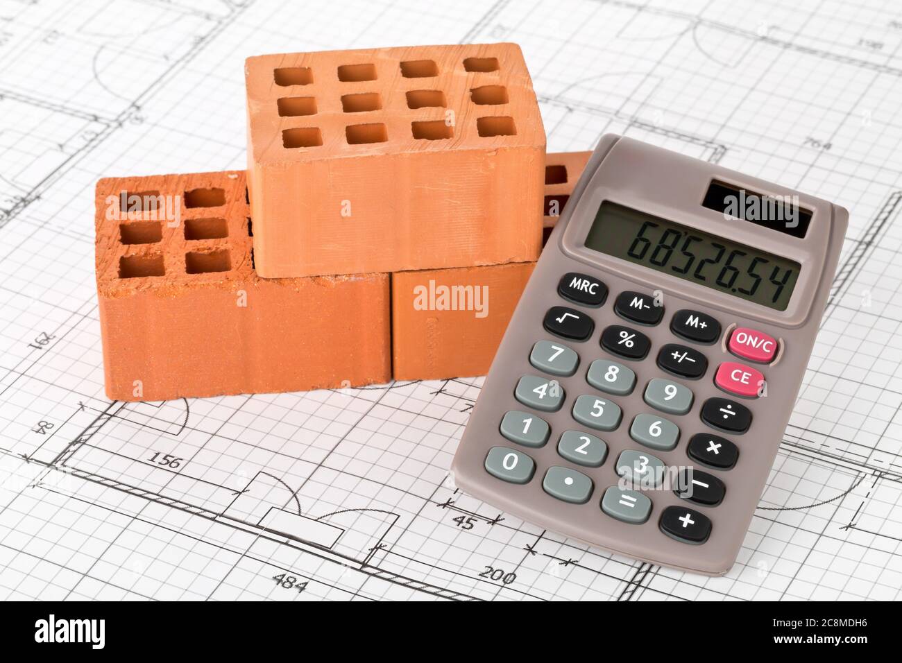 Calculator with bricks on architectural house building blueprint plan ...