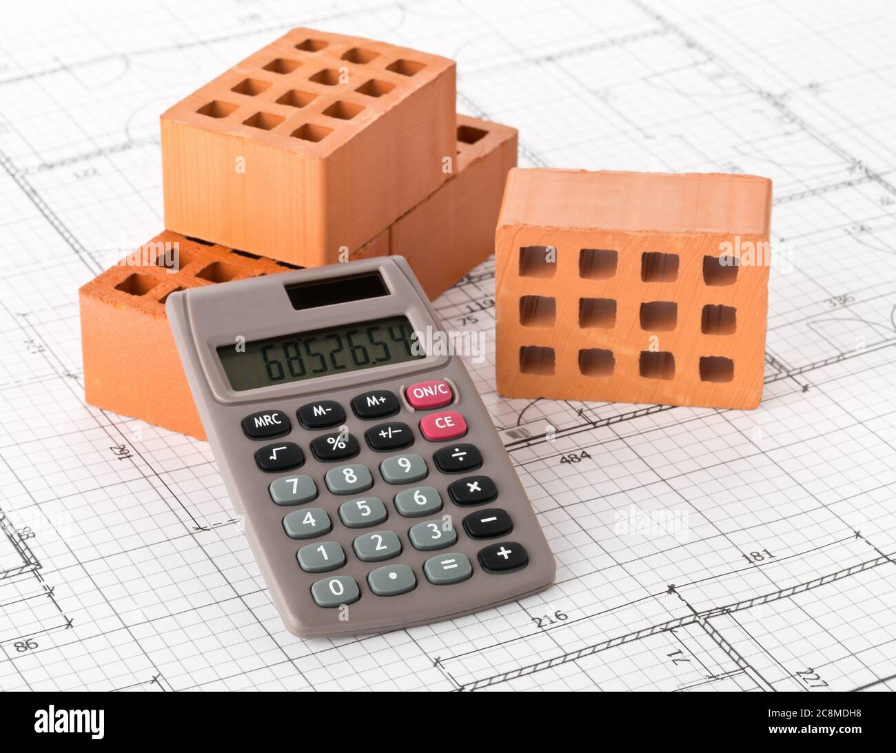 Calculator with bricks on architectural house building blueprint plan ...