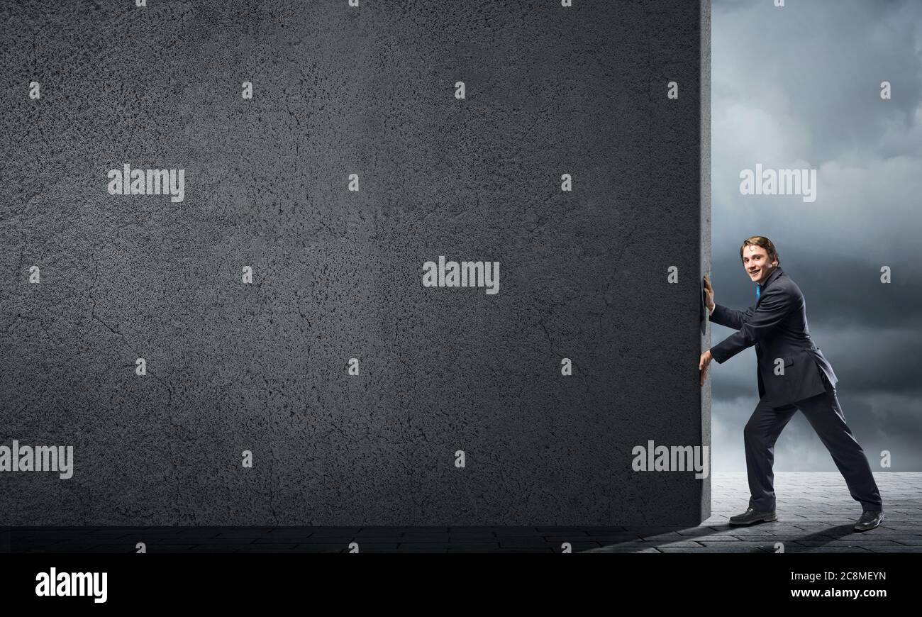 Businessman push wall Stock Photo - Alamy