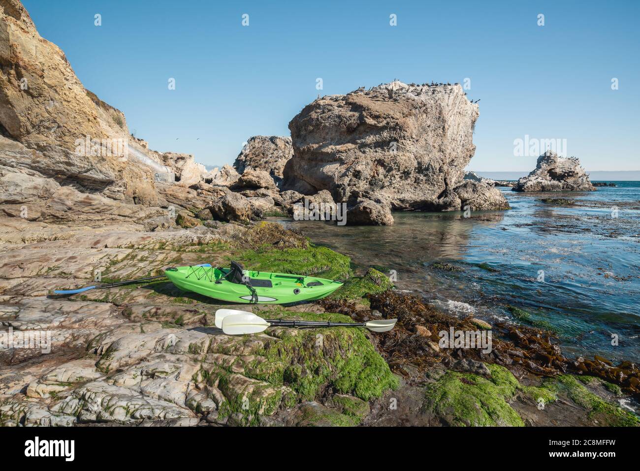 Kayak on the beach overlooking Pacific ocean and rocky cliffs with ...