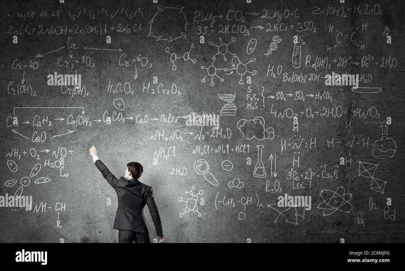 Scientist writing formulas on chalkboard Stock Photo - Alamy