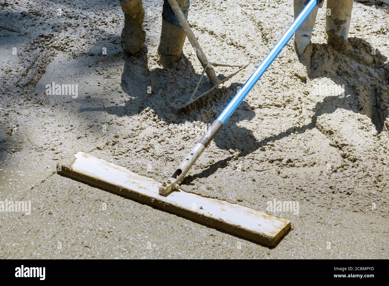 Laying down new sidewalk in wet concrete on freshly poured sidewalks ...