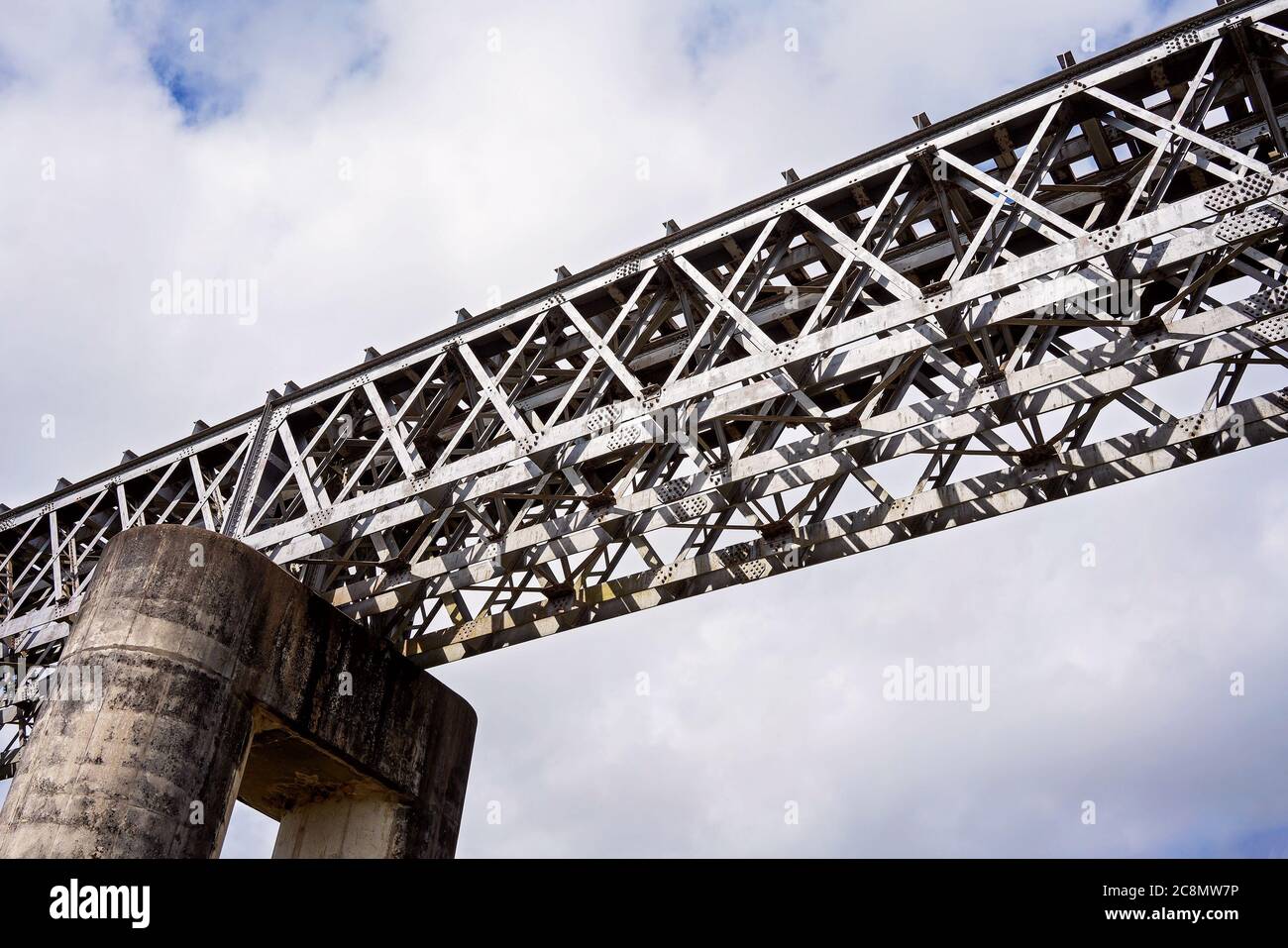 A concrete and steel railway bridge against a cloudy blue sky Stock ...