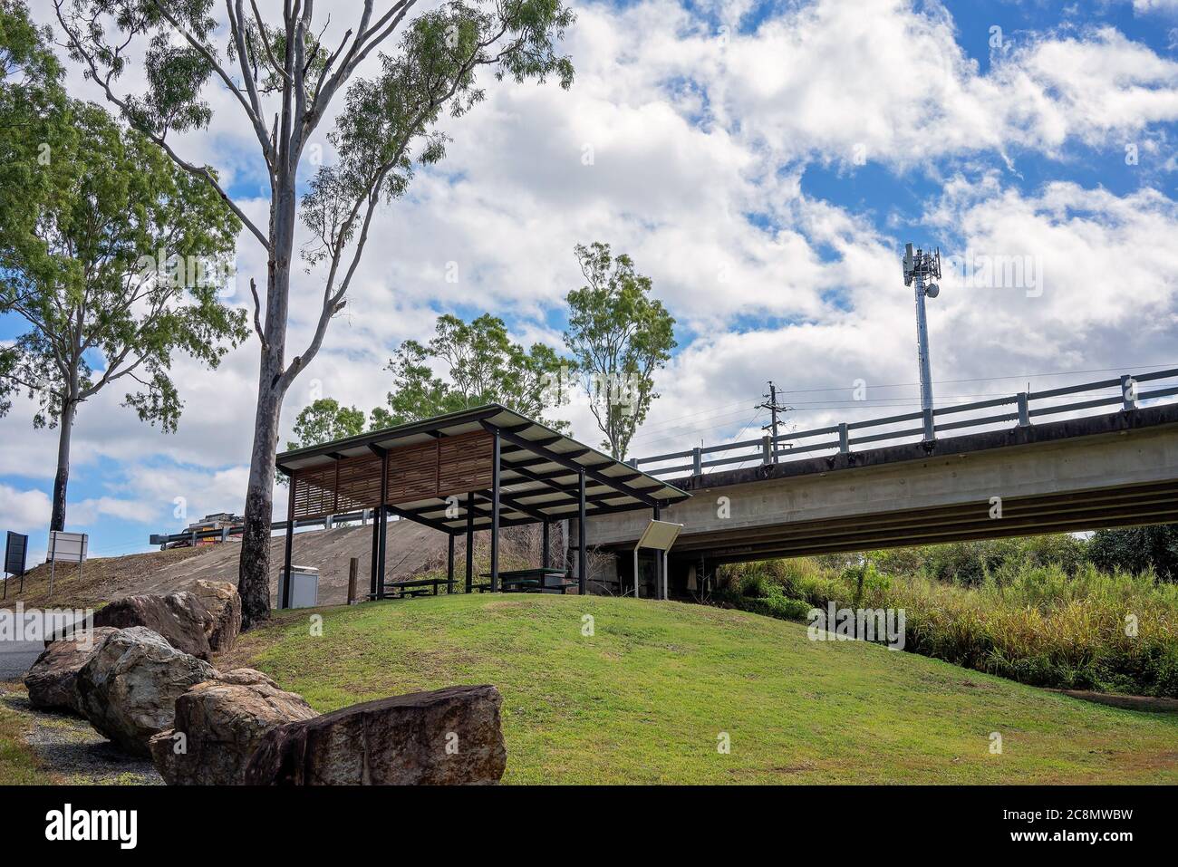 Shaded public rest area beside a country highway with a bank of grass ...