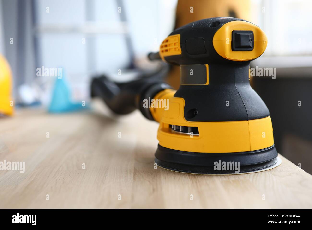 Yellow grinding machine polishes wood close up and make smooth Stock ...