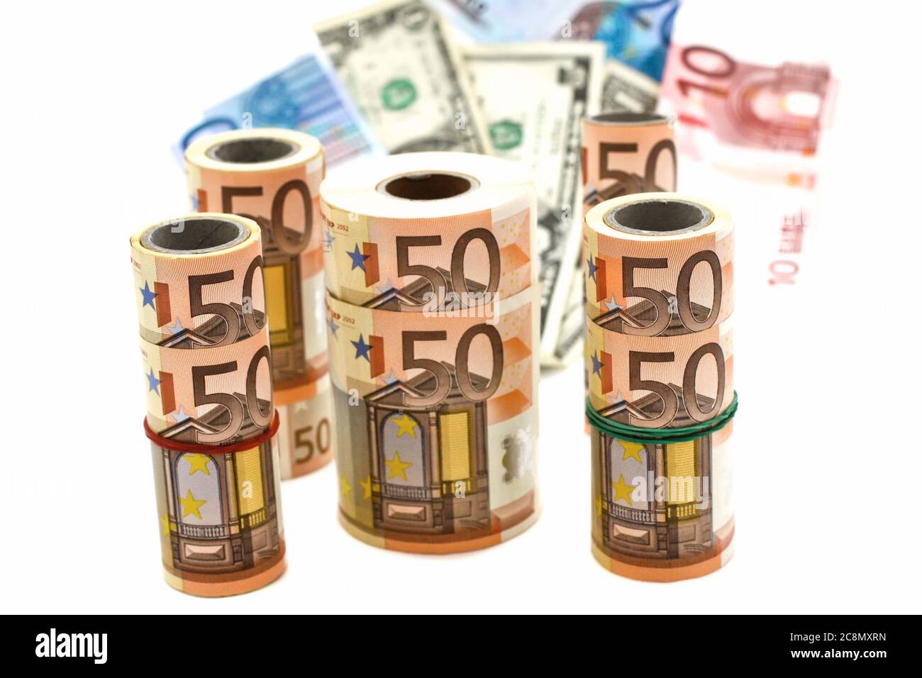 currency of different denominations in rolls and in bulk on a white ...