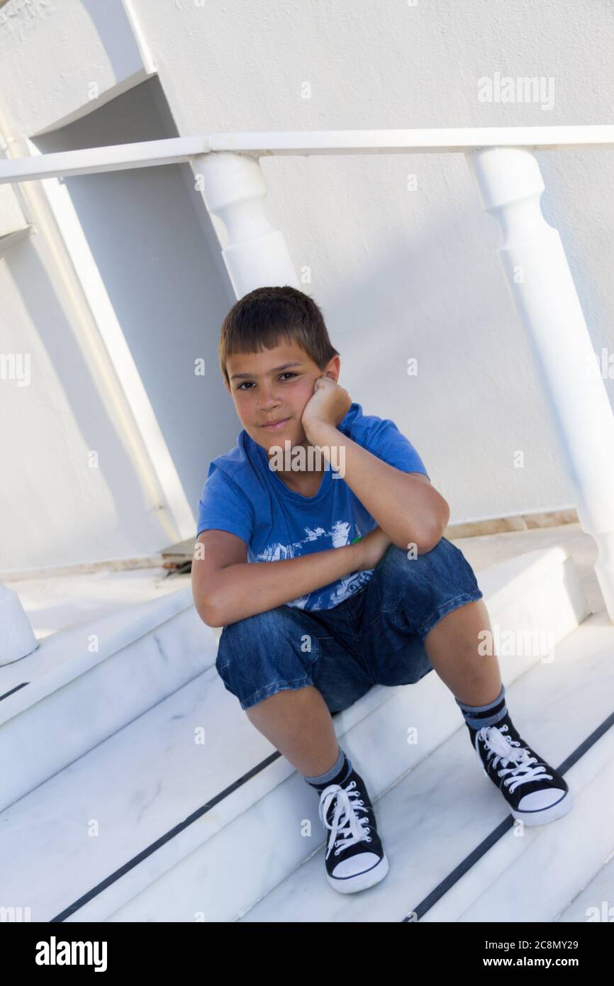 a boy in shorts and , sitting on the porch Stock Photo - Alamy