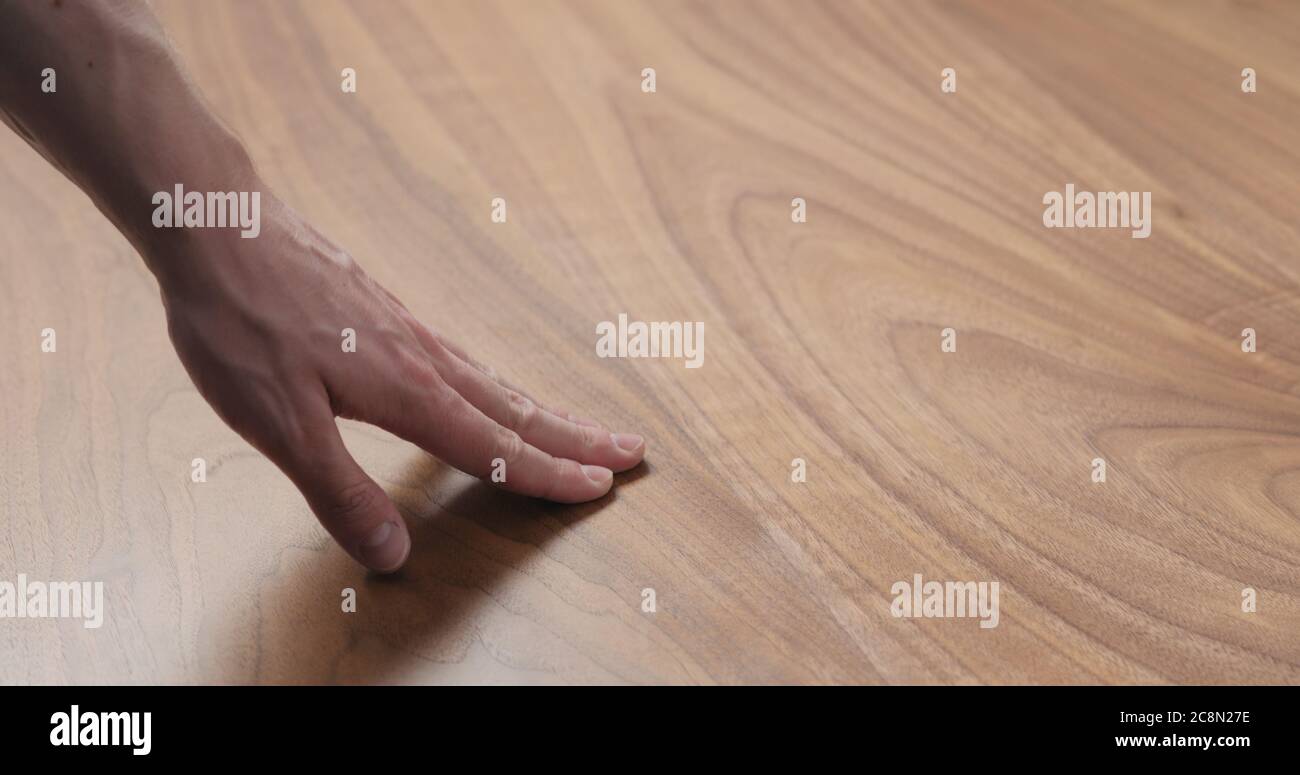 man hand touches black walnut dining table surface Stock Photo - Alamy
