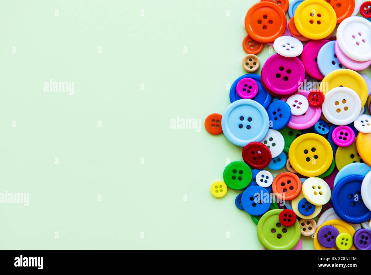 Colored sewing buttons composition on green pastel background. Flat lay ...