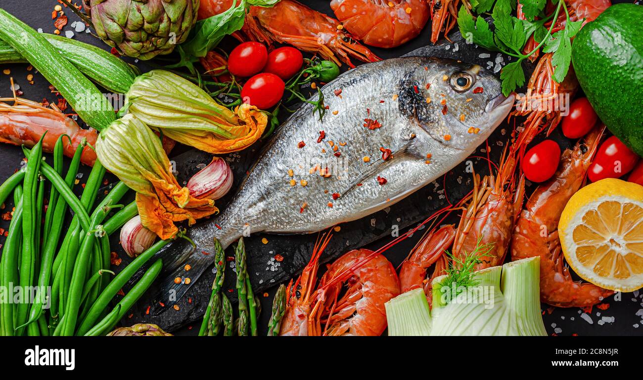 Healthy eating concept. Raw dorado fish with fresh vegetables. Flat lay ...
