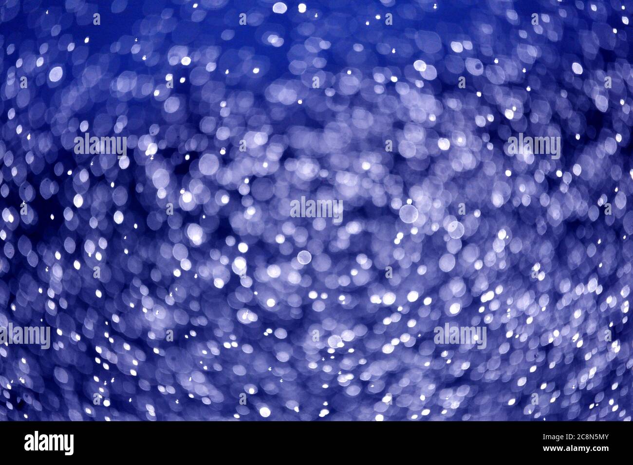 flying waterdrops against the sunrays on a dark background image Stock ...