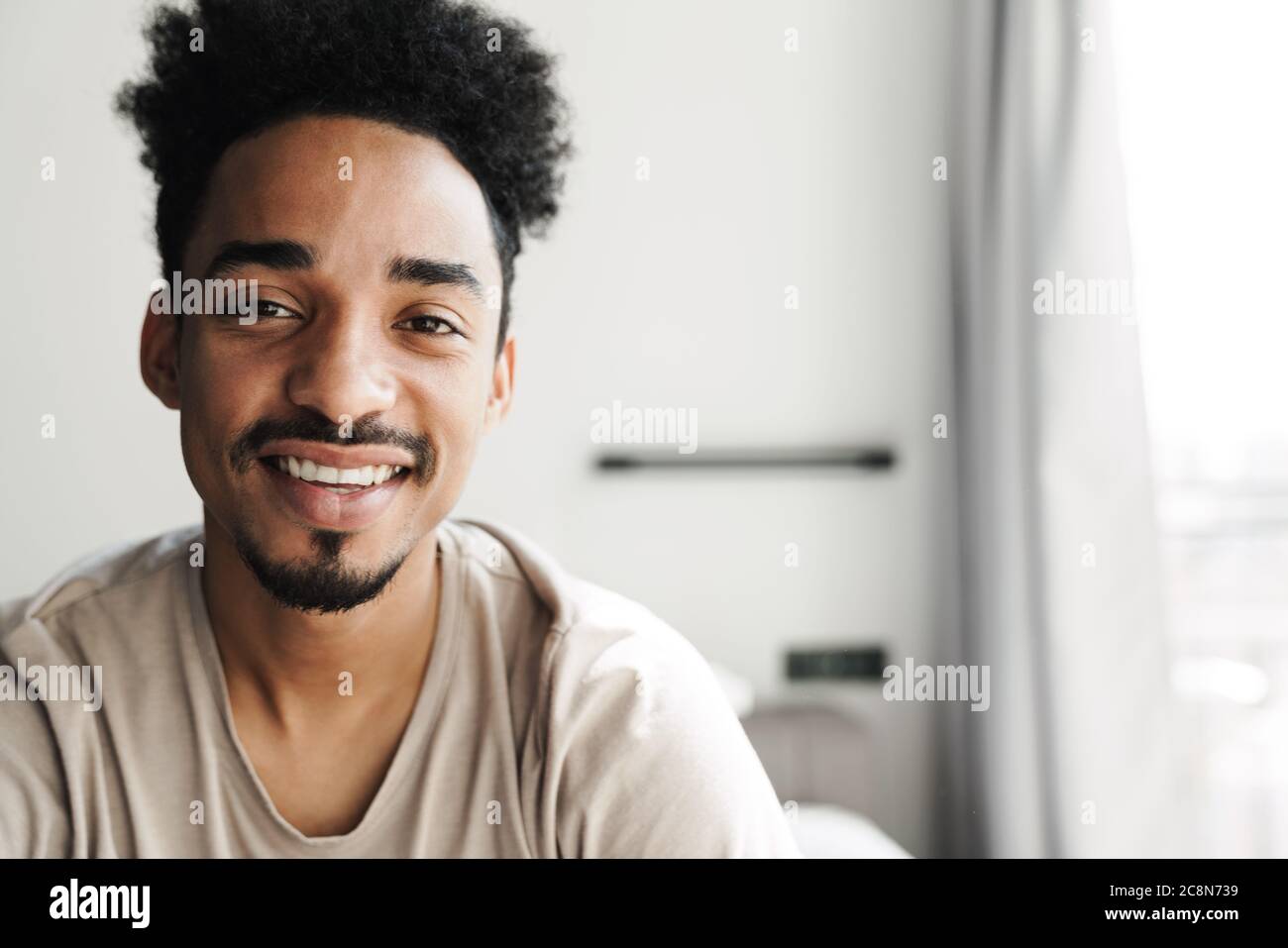 Photo of happy african american man with beard smiling after sleep in ...