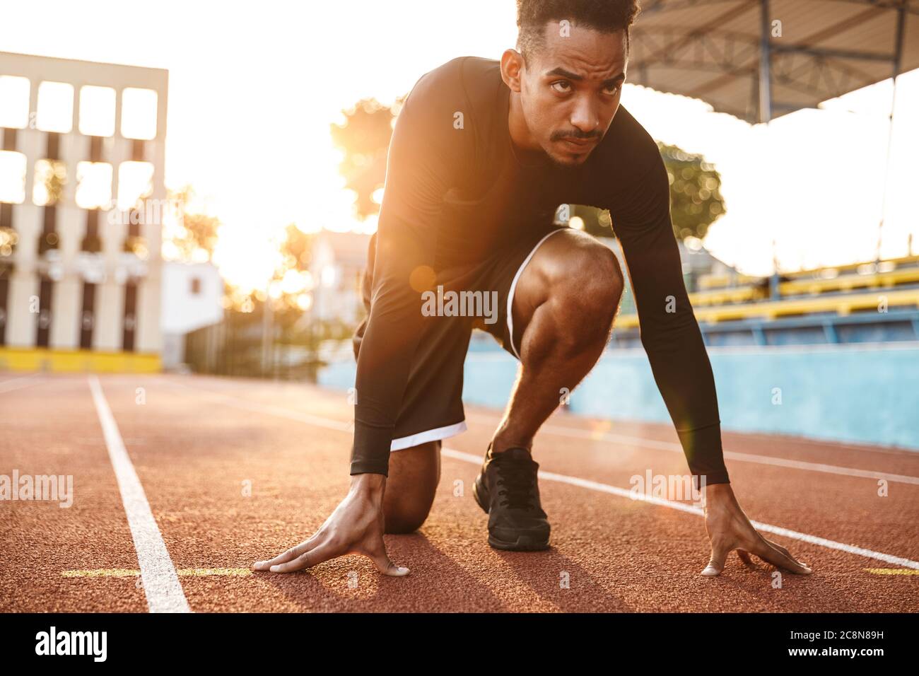 Image of young african american man getting ready to run on sports ...