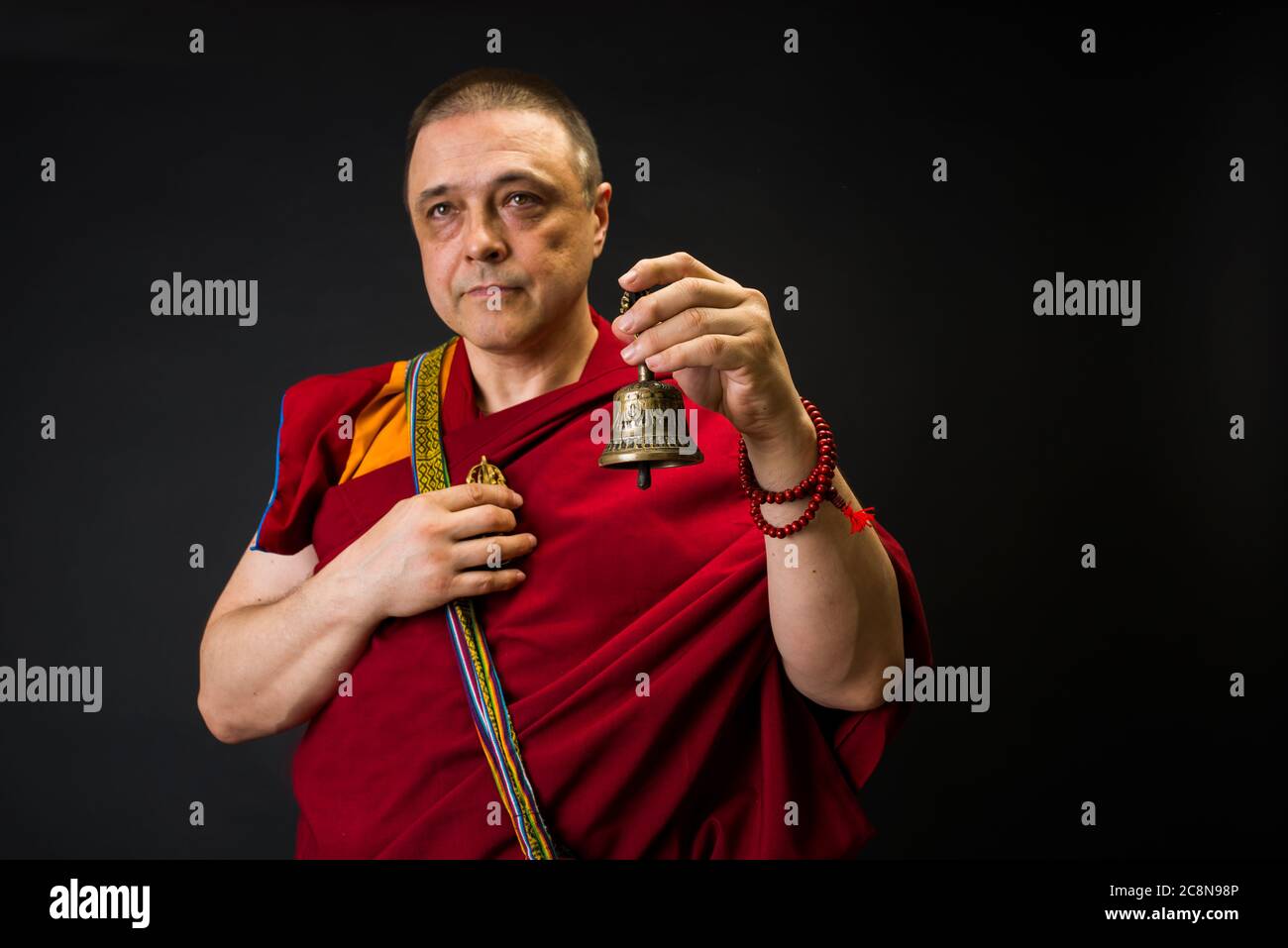 The monk holds a prayer drum in his hand. portrait of a Buddhist monk ...